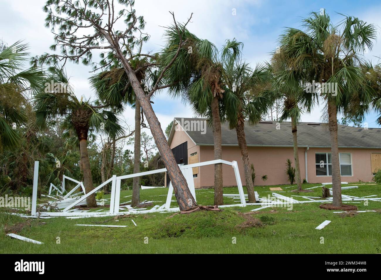 Hurricane damage to white PVC backyard fence ruined after tree debris ...