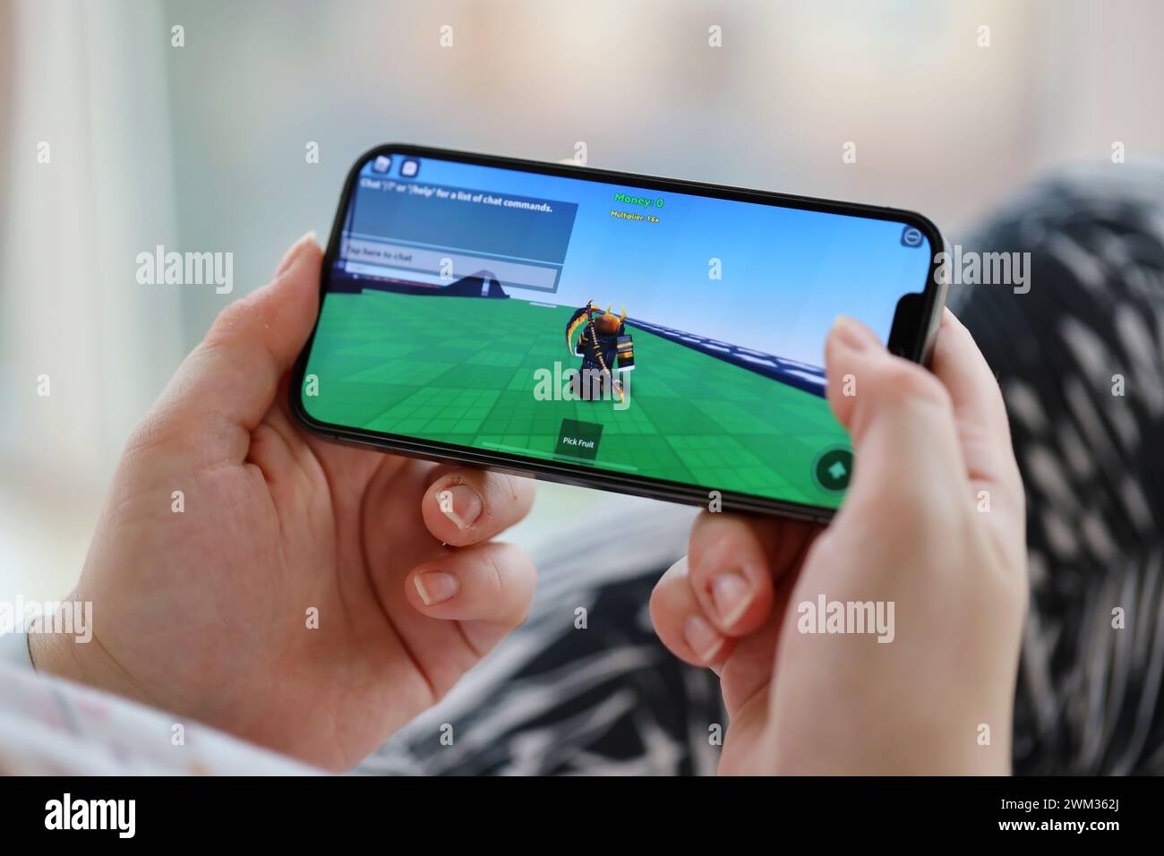 Roblox mobile iOS game on iPhone 15 smartphone screen in female hands ...