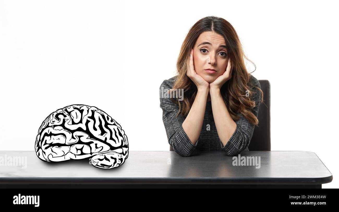 Young woman with a facial expression of boredom, sitting at her desk ...