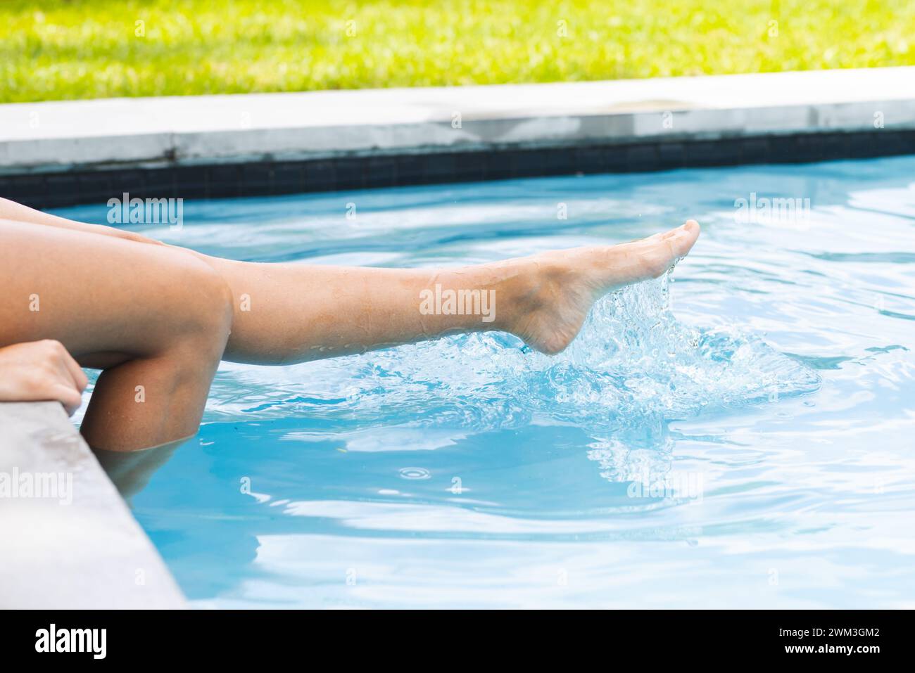 Person enjoys a refreshing dip in a pool on a sunny day, with copy ...