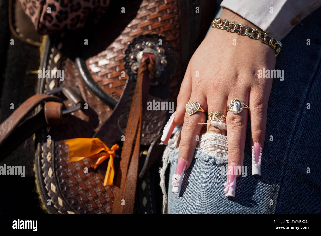 Kaitlyn Colunga, 16, wears jewelry as her horse "Red" drinks water ...