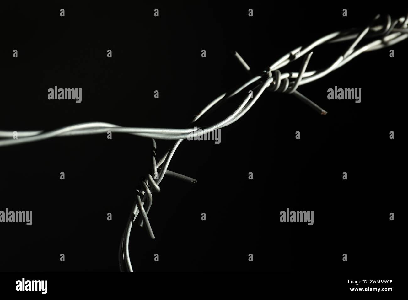 Metal barbed wire on black background, closeup Stock Photo - Alamy