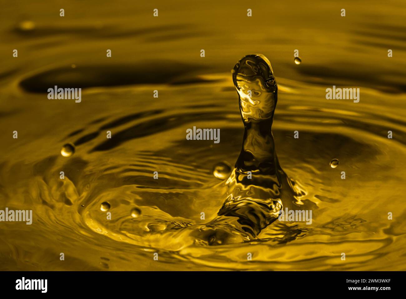 Splash of golden oily liquid with drops as background, closeup Stock ...