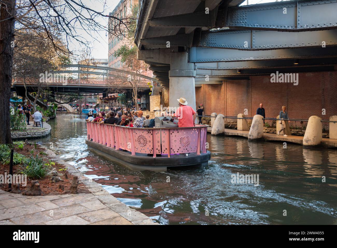 Colorful pink boat cruise with tour guide on the San Antonio River Walk ...