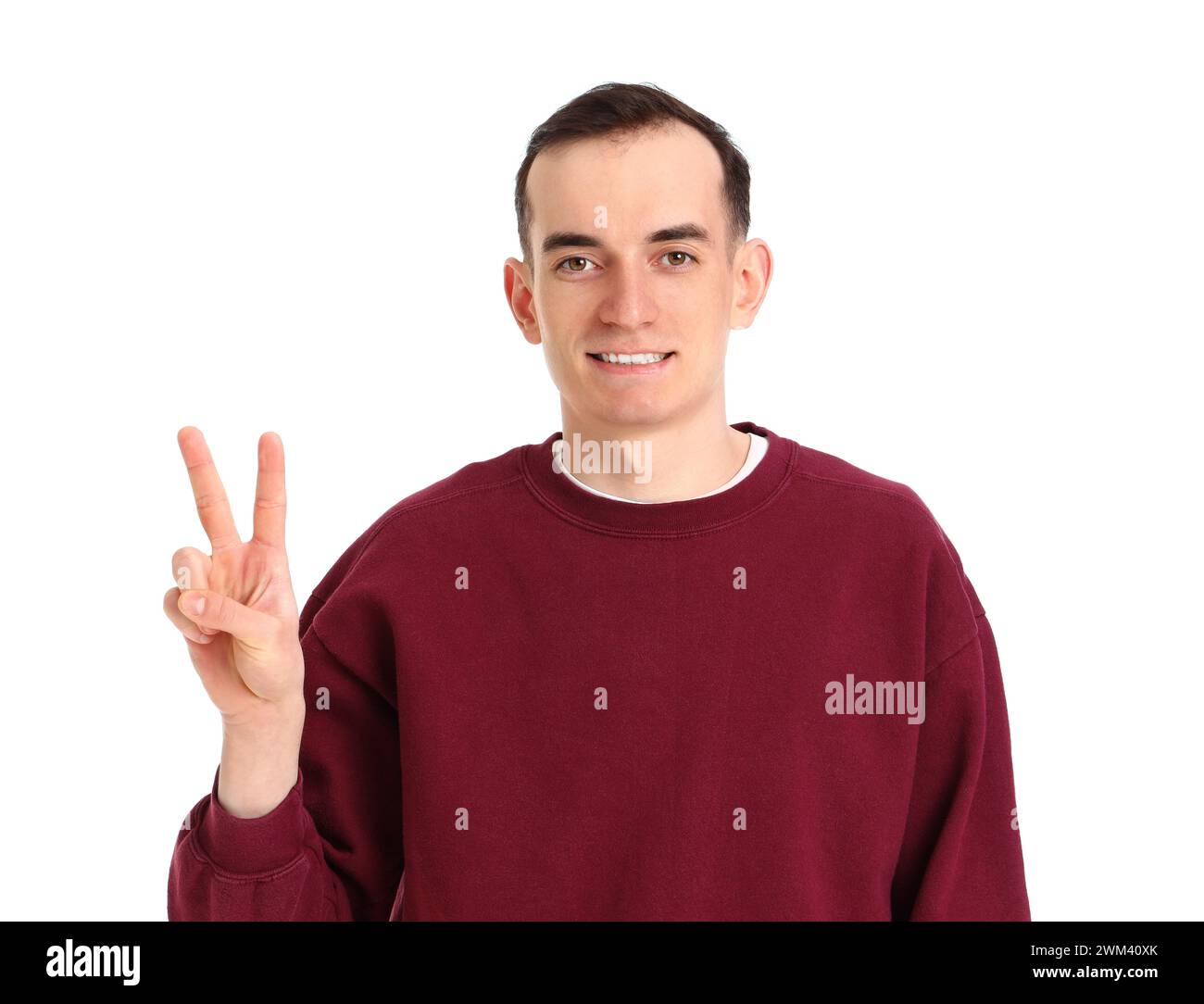 Young man showing two fingers on white background Stock Photo - Alamy