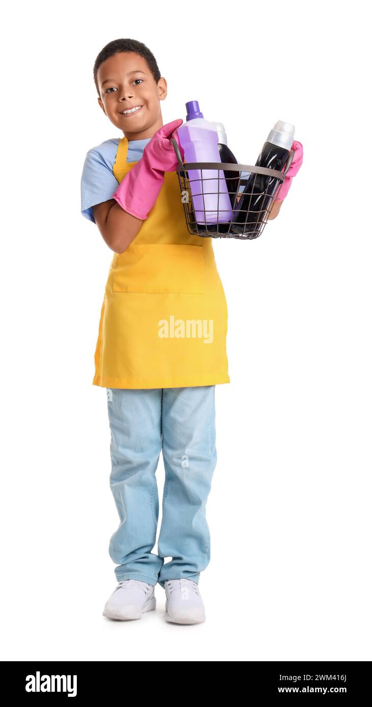Little African-American boy with cleaning supplies in basket on white ...