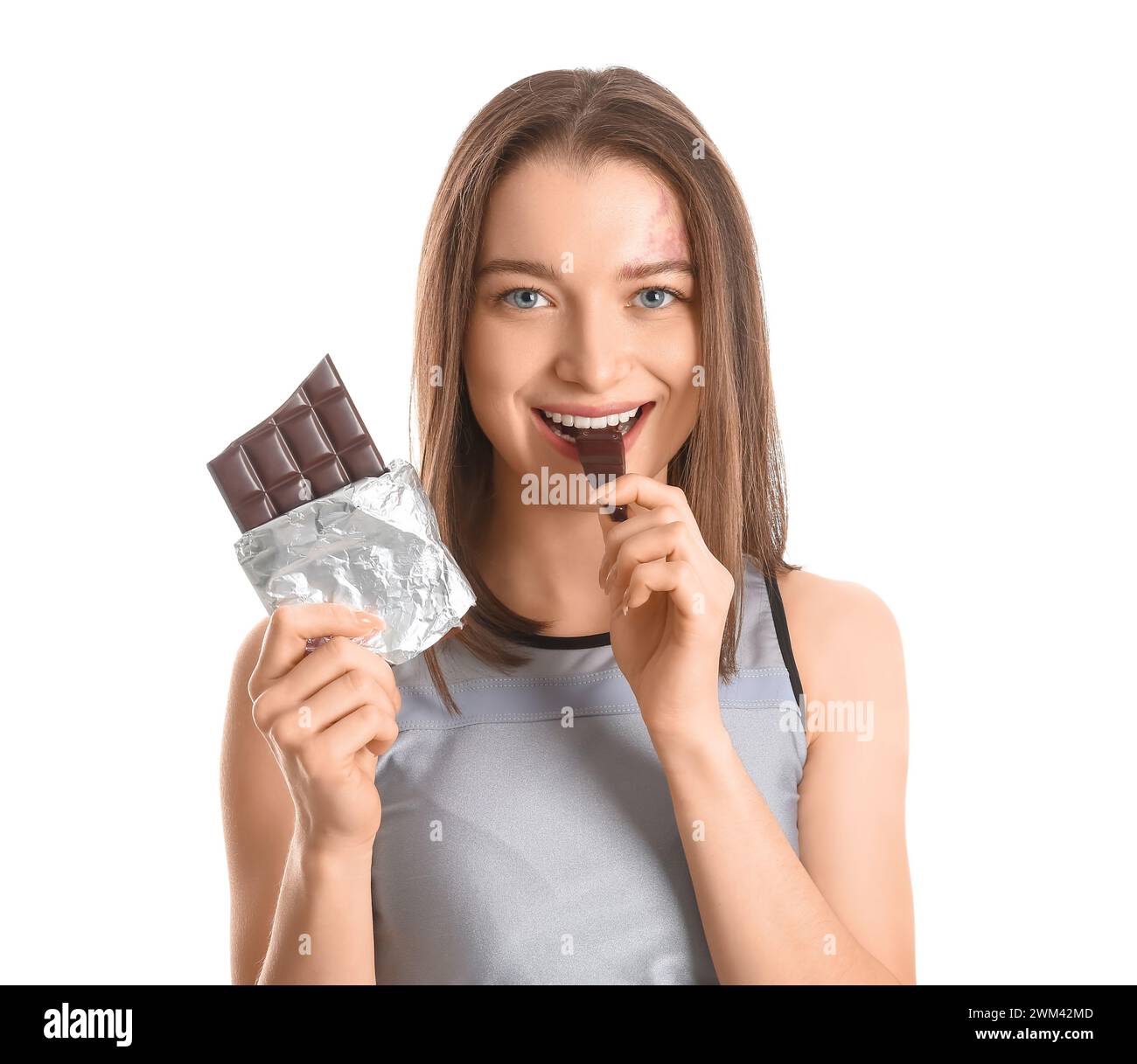 Young woman eating chocolate bar on white background Stock Photo - Alamy