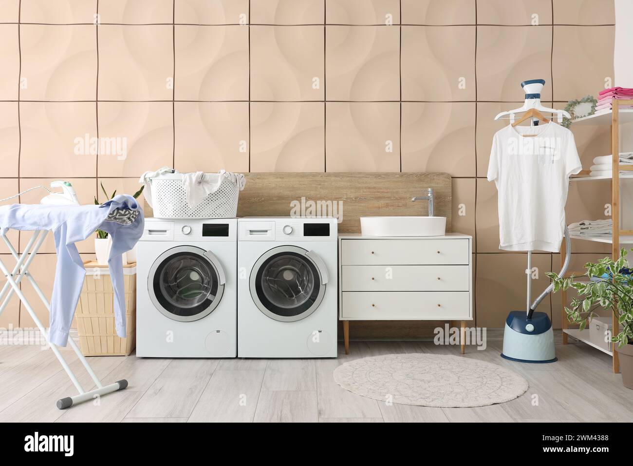 Interior of laundry room with washing machines, garment steamer and ...