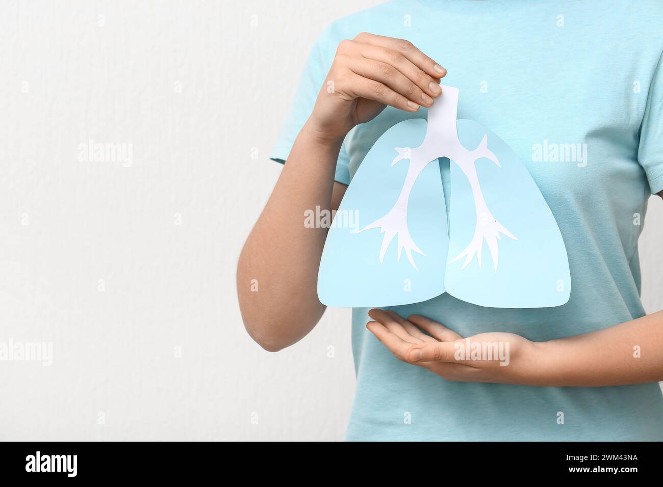 Young woman with blue paper lungs on white background Stock Photo - Alamy