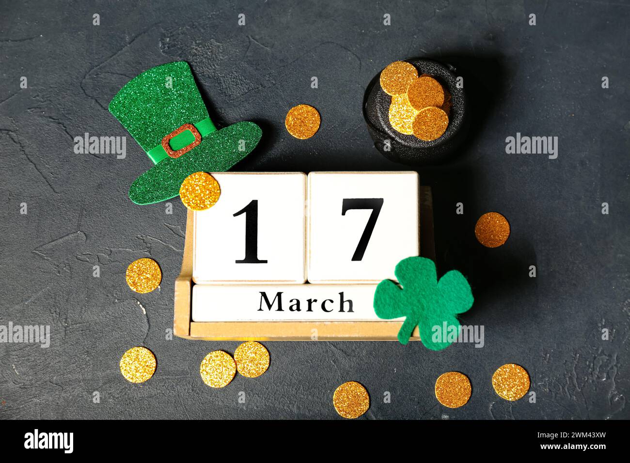 Leprechaun pot with golden coins and wooden calendar on black ...