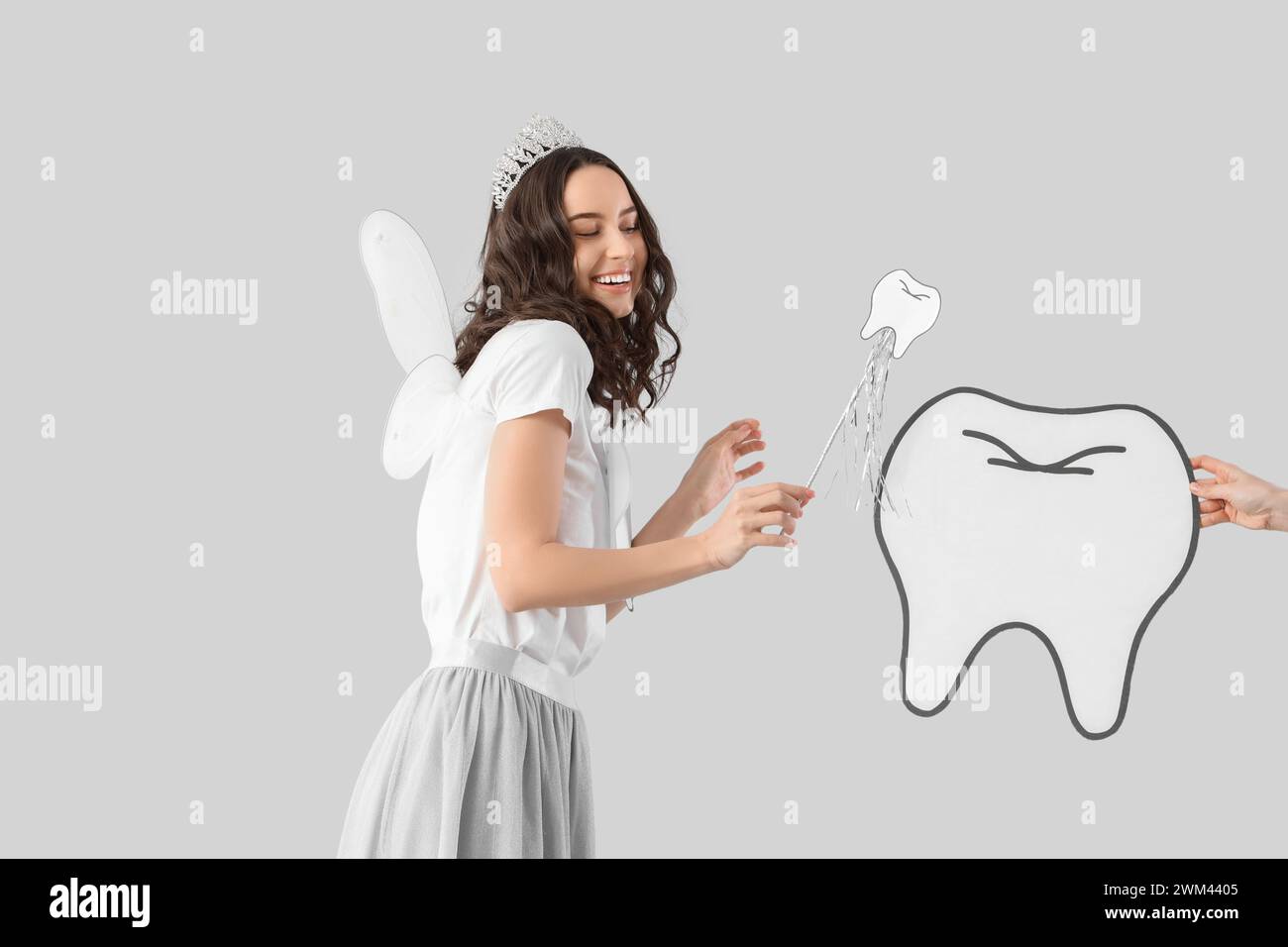 Tooth Fairy with wand and paper figure on light background Stock Photo ...