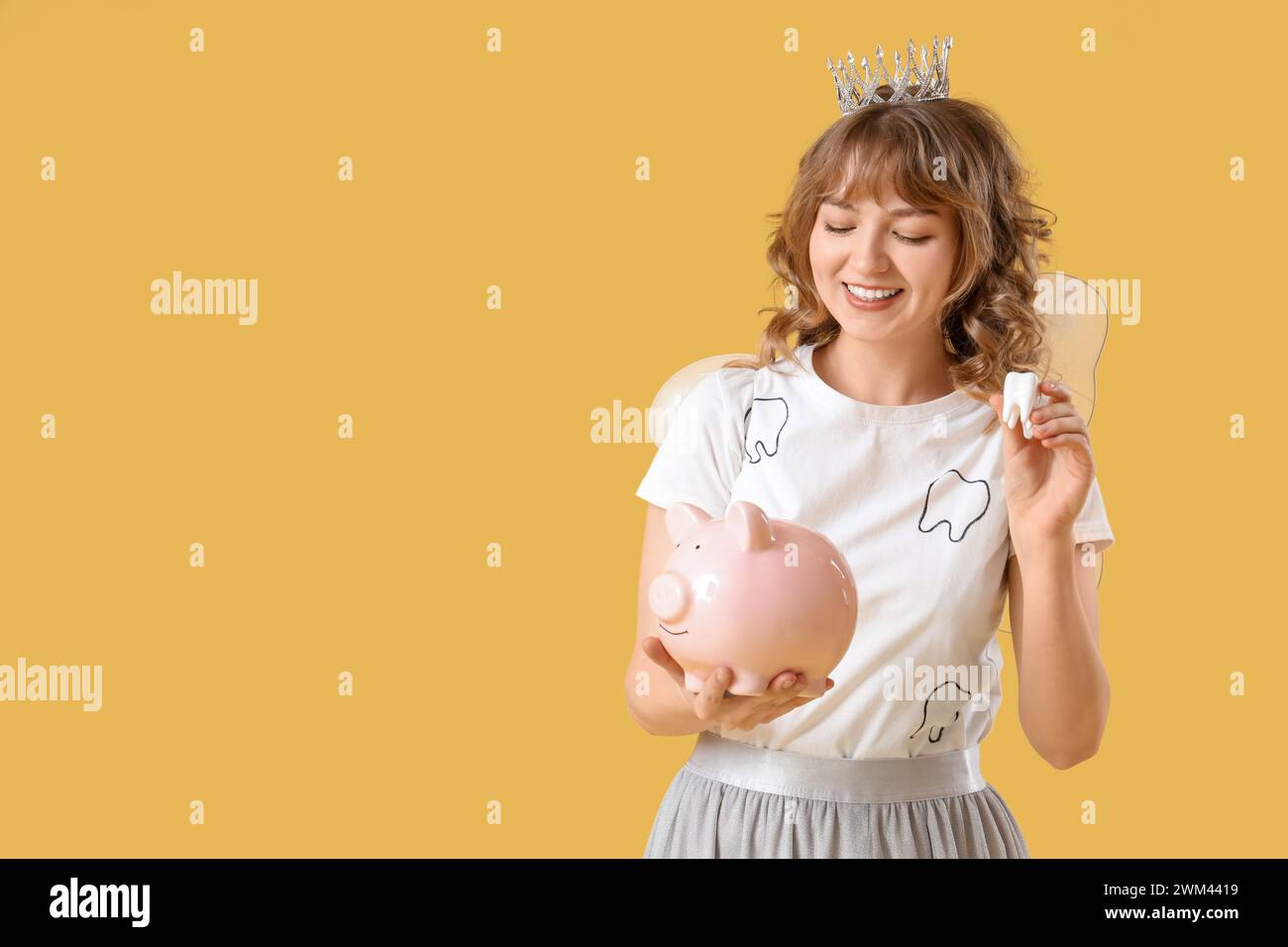 Tooth Fairy with piggy bank and plastic figure on yellow background ...