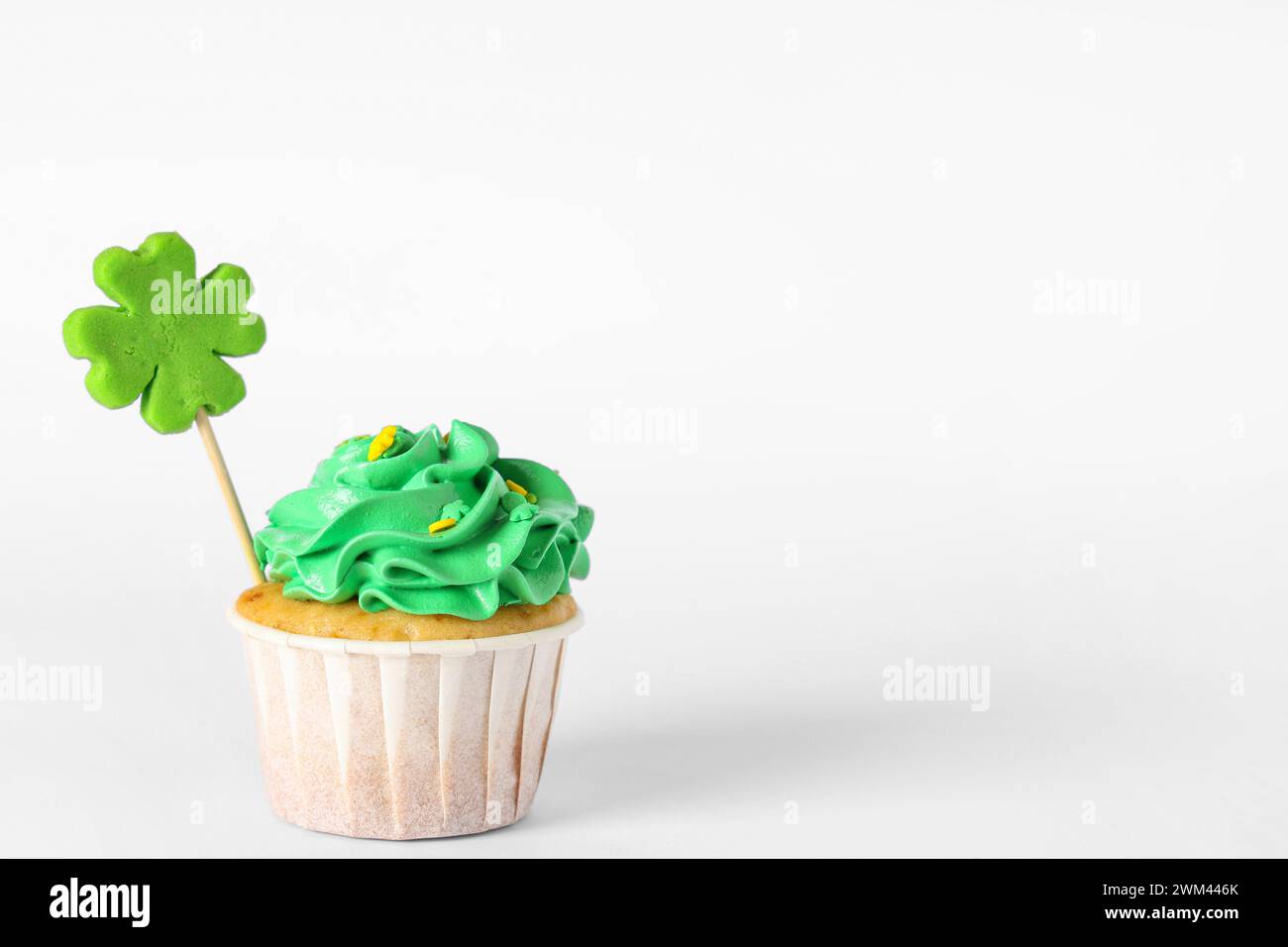 Tasty green cupcake with clover for St. Patrick's Day on white ...