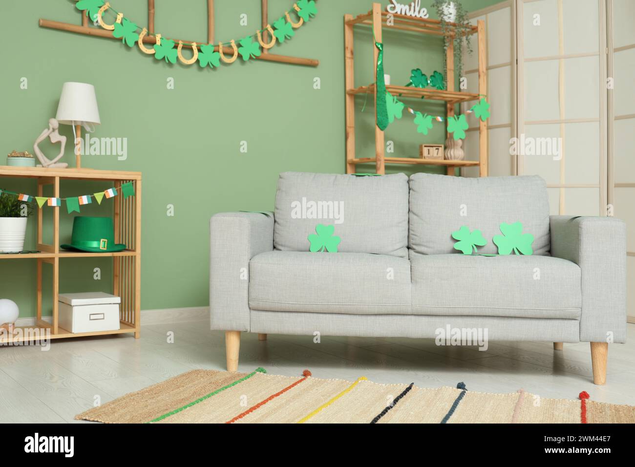 Interior of festive living room with grey sofa and decorations for St ...