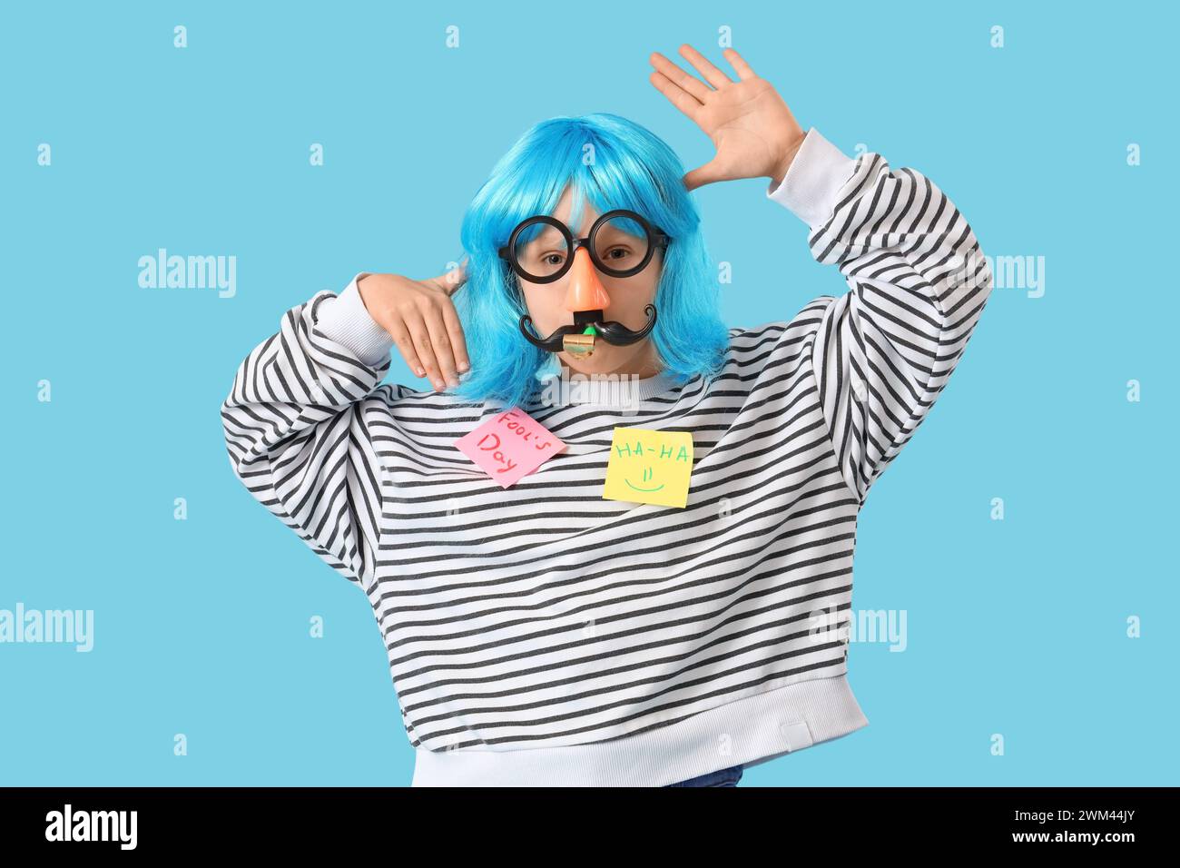 Funny little girl in disguise with party blower and sticky papers on ...