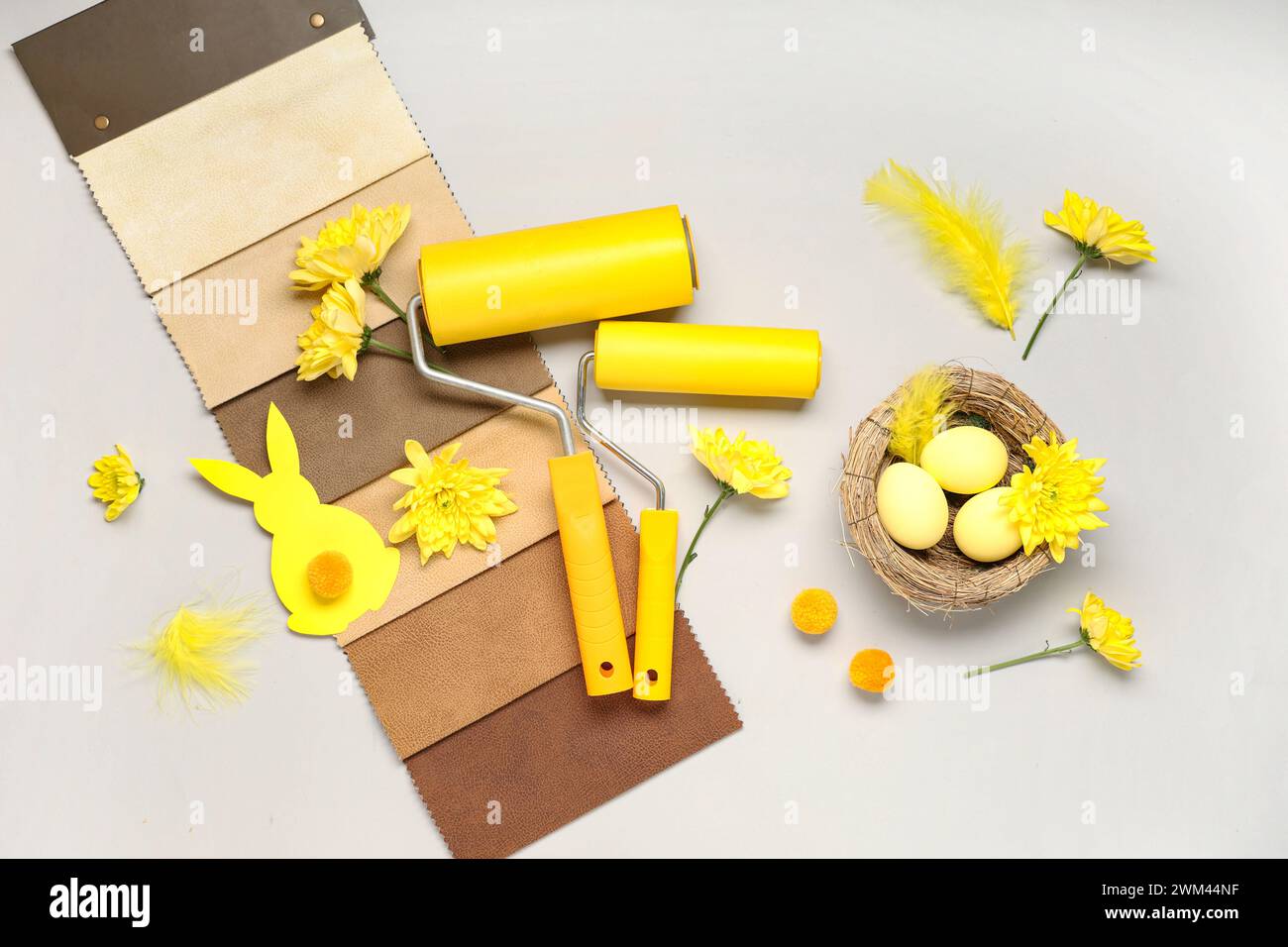 Composition with paint rollers, fabric samples, Easter eggs and flowers ...