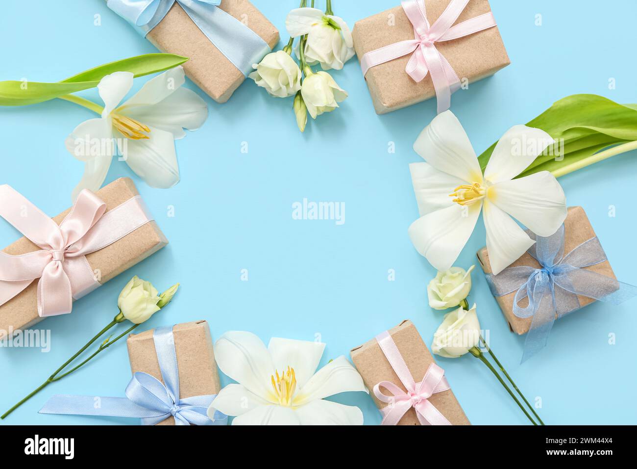 Spring frame made of wrapped gift boxes and flowers on cyan background ...