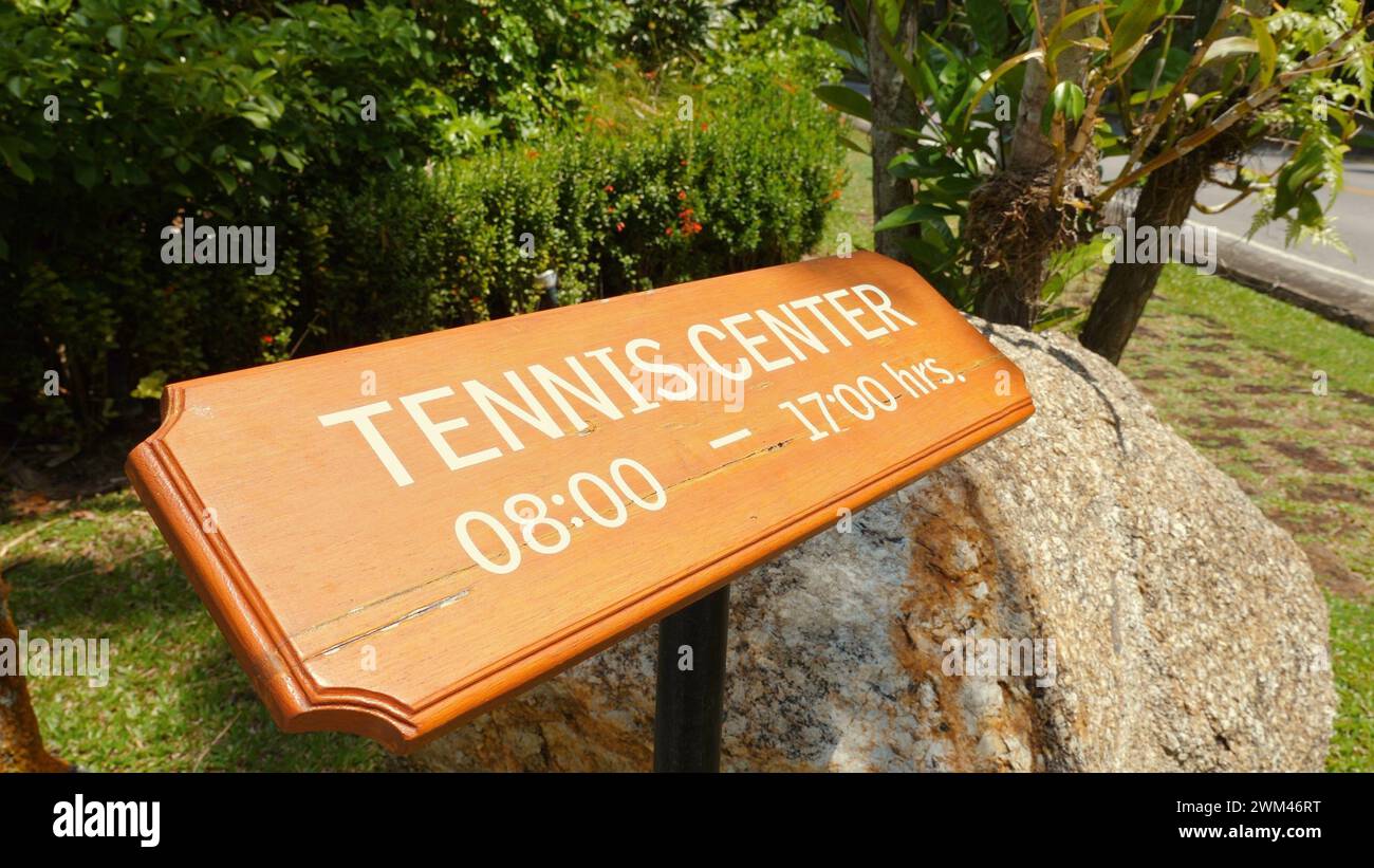 Tennis center information sign displayed on wooden board with operation ...