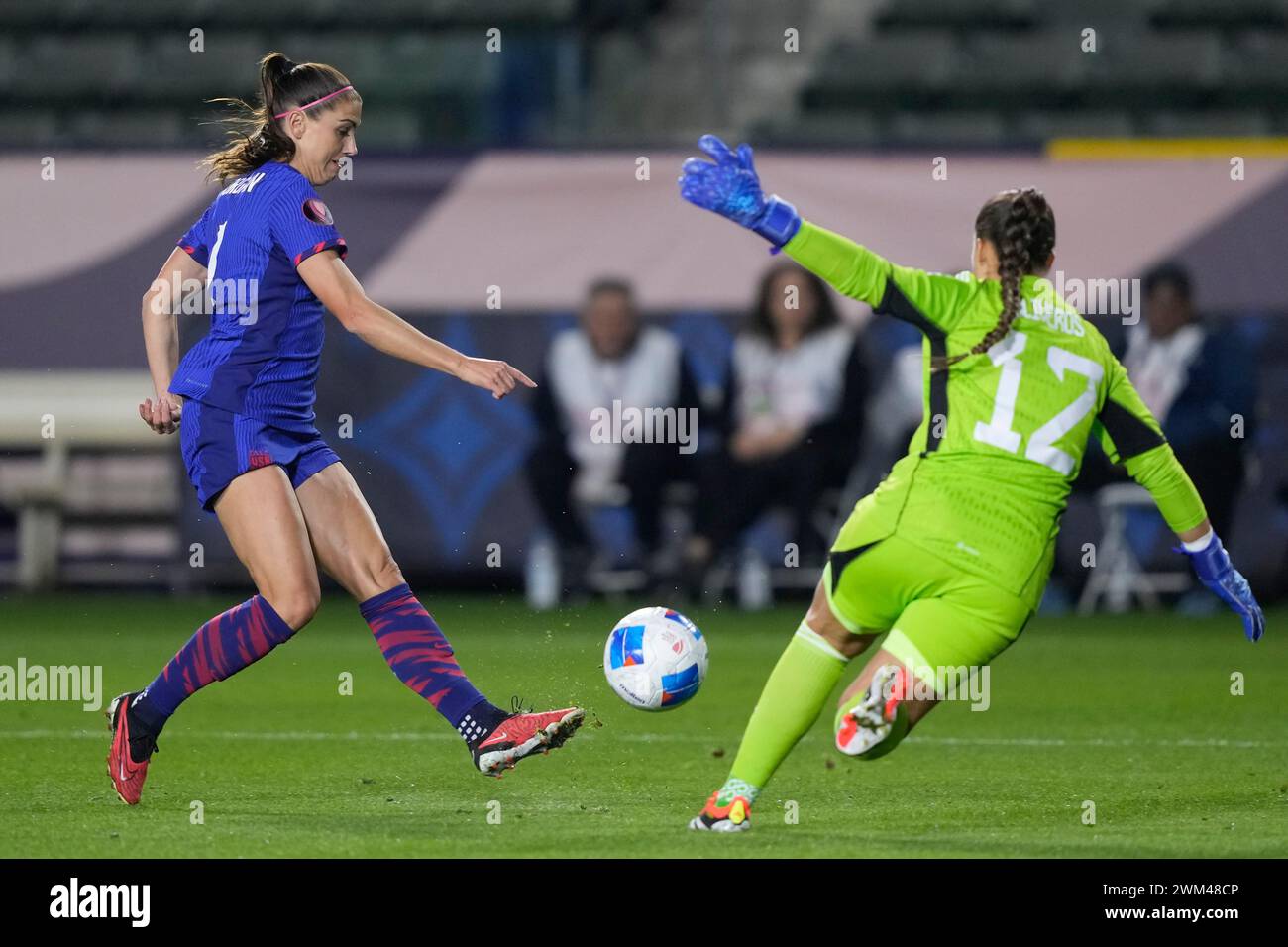 U.S. forward Alex Morgan, left, shoots against Argentina goalkeeper ...