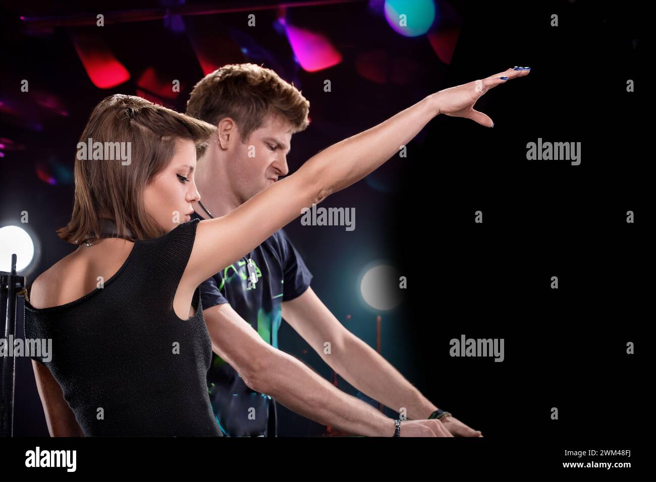concentrated expressions of two DJs at work, blending sounds under the ...