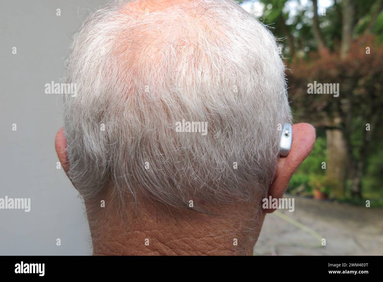 Deaf senior citizen man wearing modern digital high technology hearing ...
