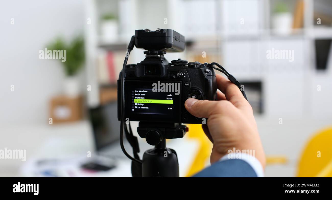 Male arms in suit mount camcorder to tripod making promo videoblog or ...