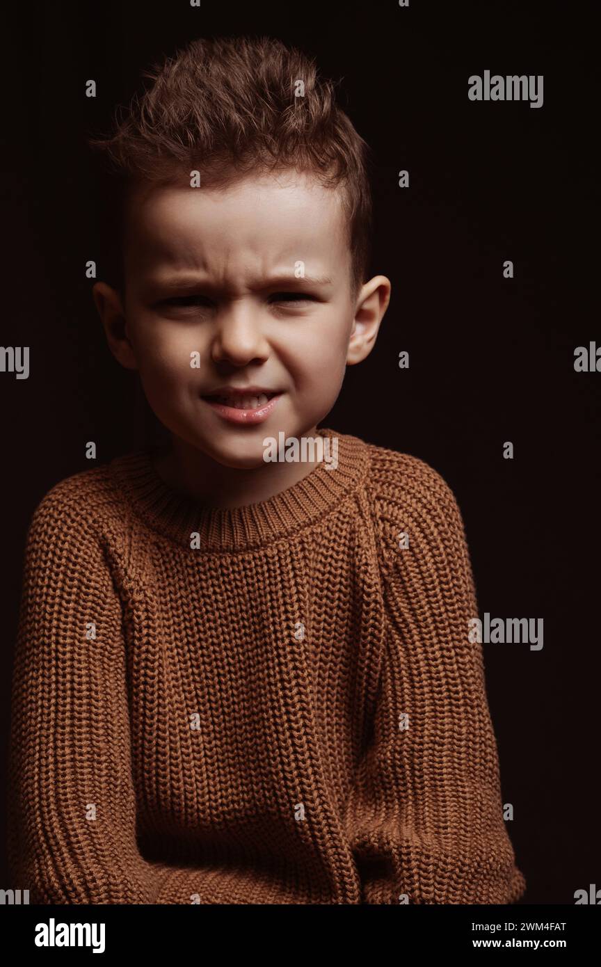 Portrait of a frowning serious angry stylish white Caucasian child boy ...