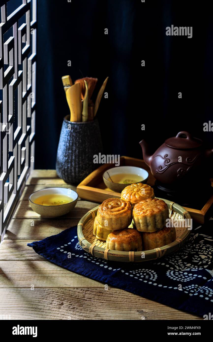 Homemade moon cakes on table and tea pot and cup set at the dark ...