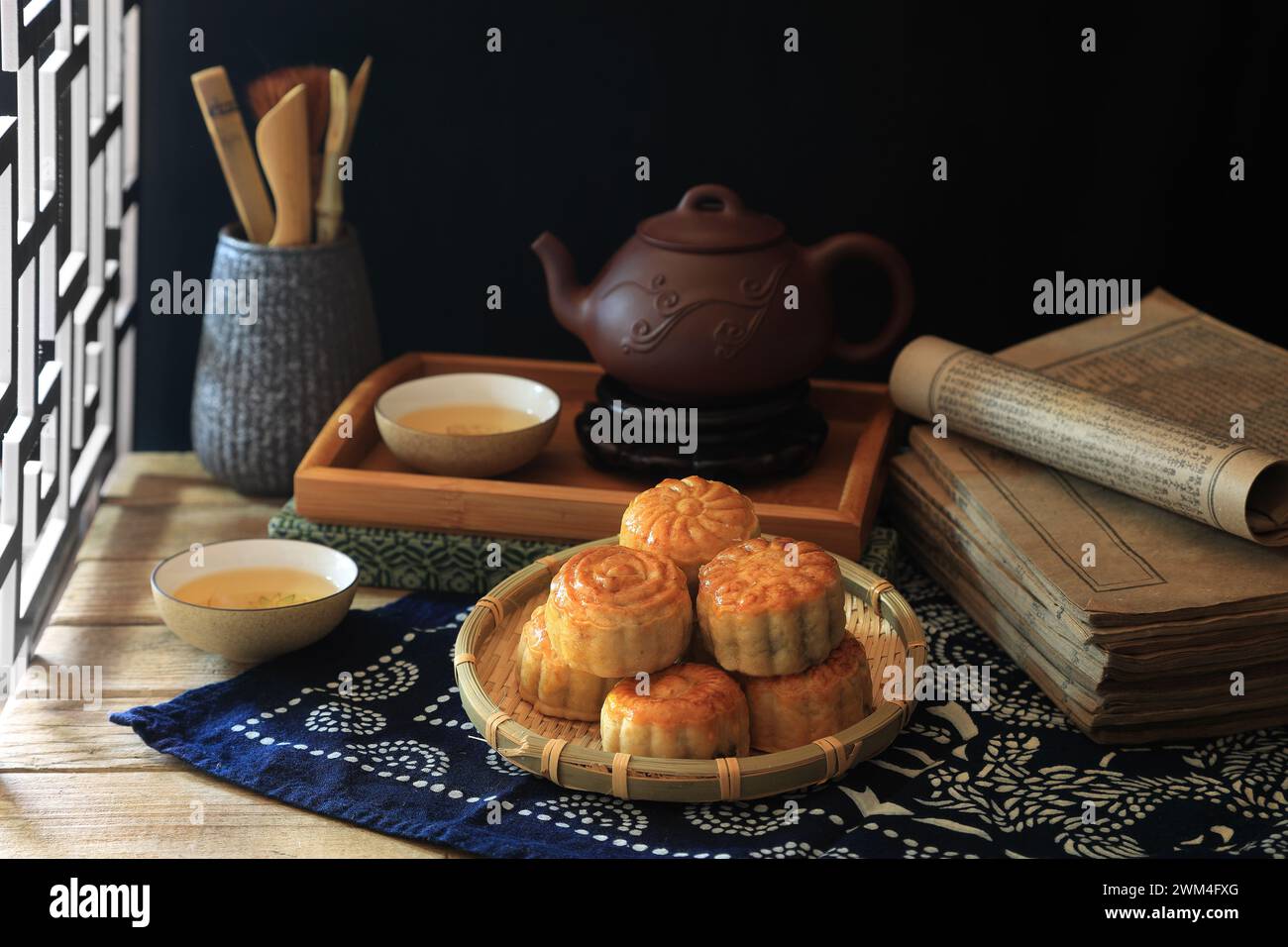 Homemade moon cakes on table and tea pot and cup set at the dark ...