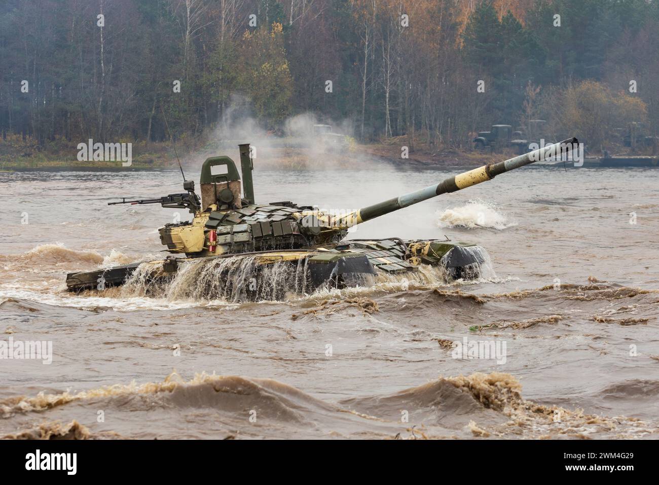 A powerful heavy fighting vehicle tank leaves the river bank after ...