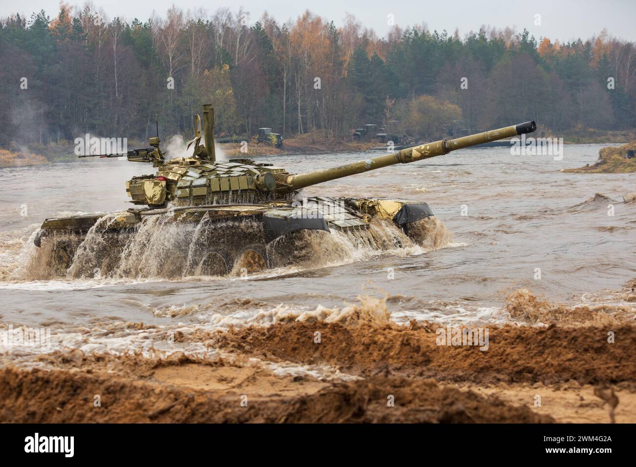 A powerful heavy fighting vehicle tank leaves the river bank after ...
