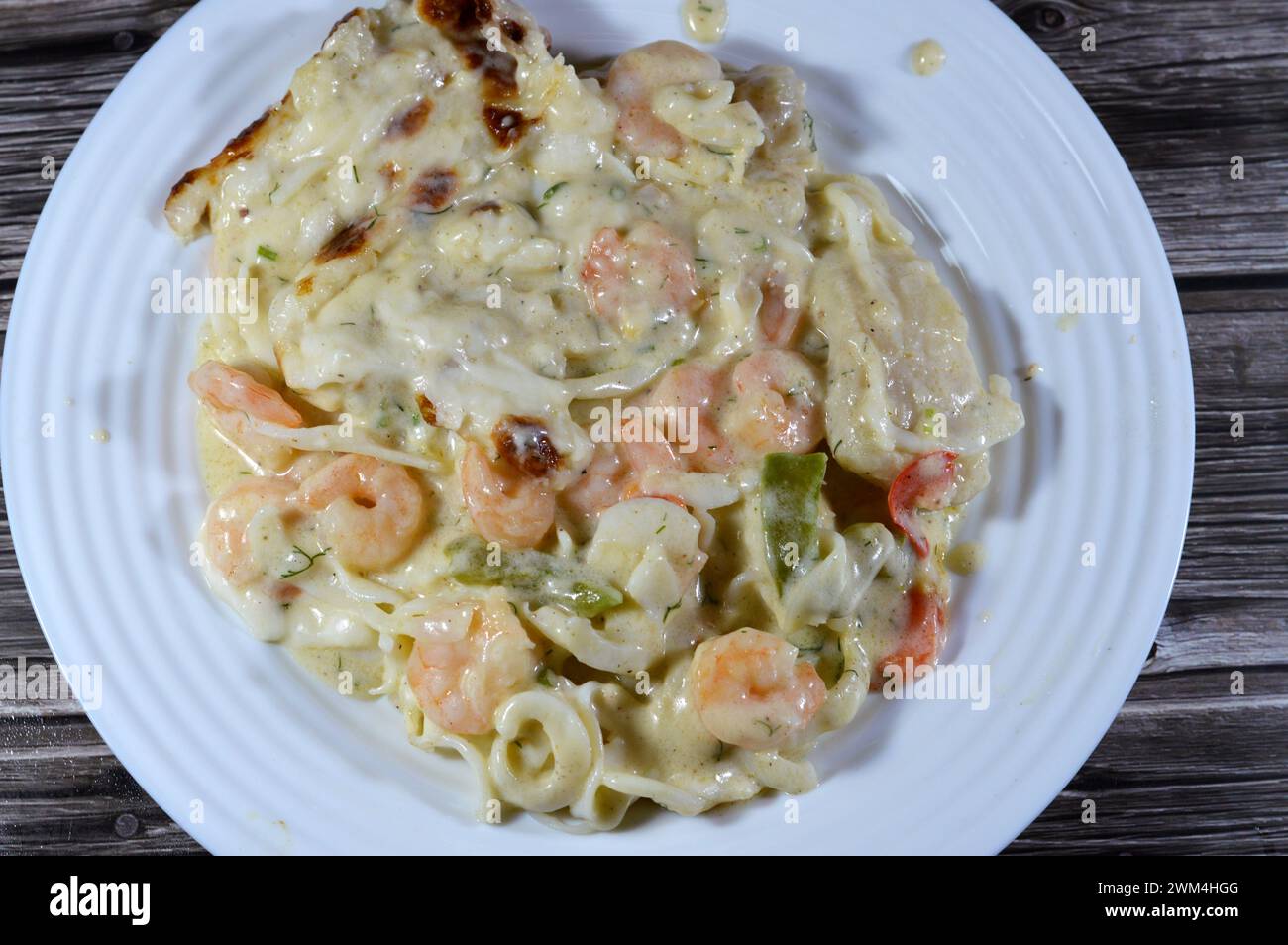 Creamy seafood baked mix of shrimps, squid calamari, fish fillet ...