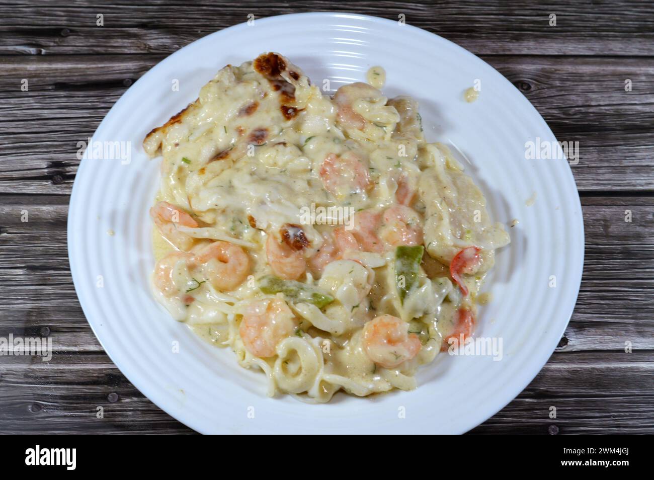 Creamy seafood baked mix of shrimps, squid calamari, fish fillet ...