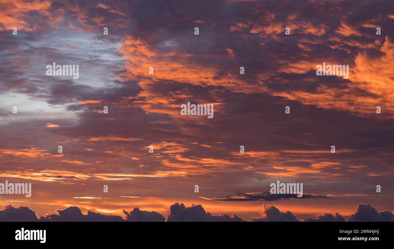 Dramatic sunset with vibrant clouds lit by a sun, nature background ...