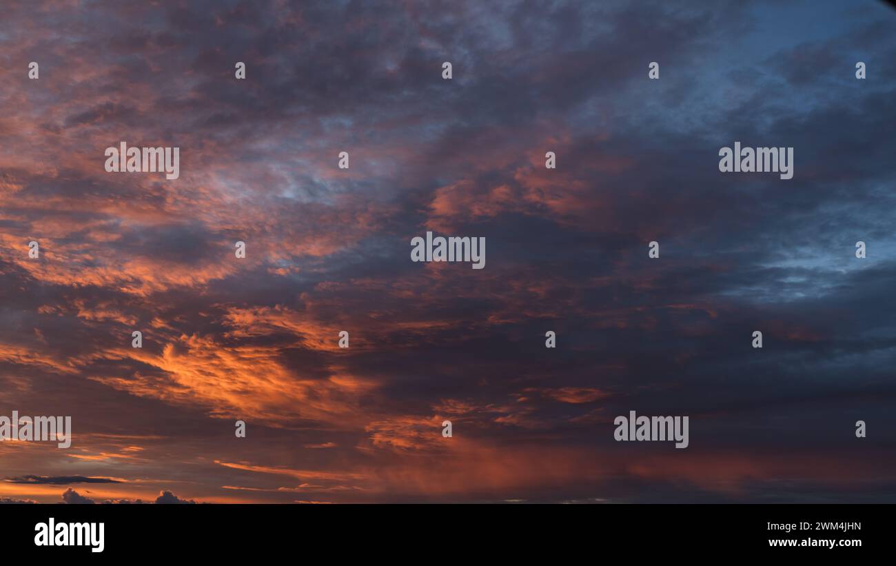 Dramatic sunset with vibrant clouds lit by a sun, nature background ...
