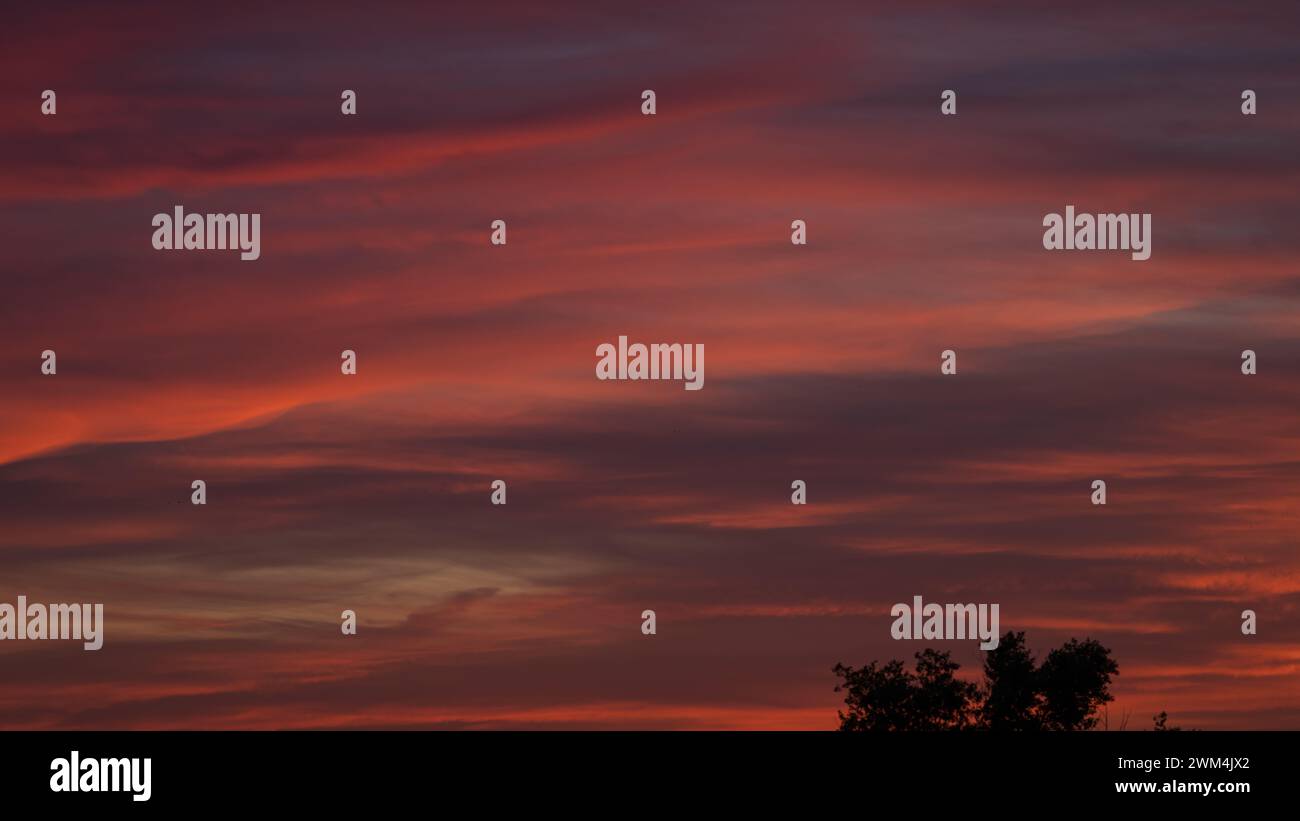 Dramatic sunset with vibrant clouds lit by a sun, nature background ...
