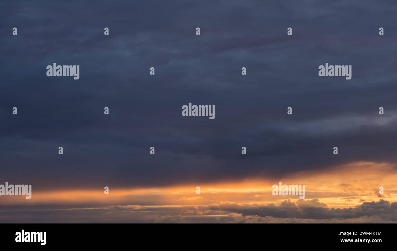 Dramatic yellow sunset with vibrant clouds lit by a sun, nature ...