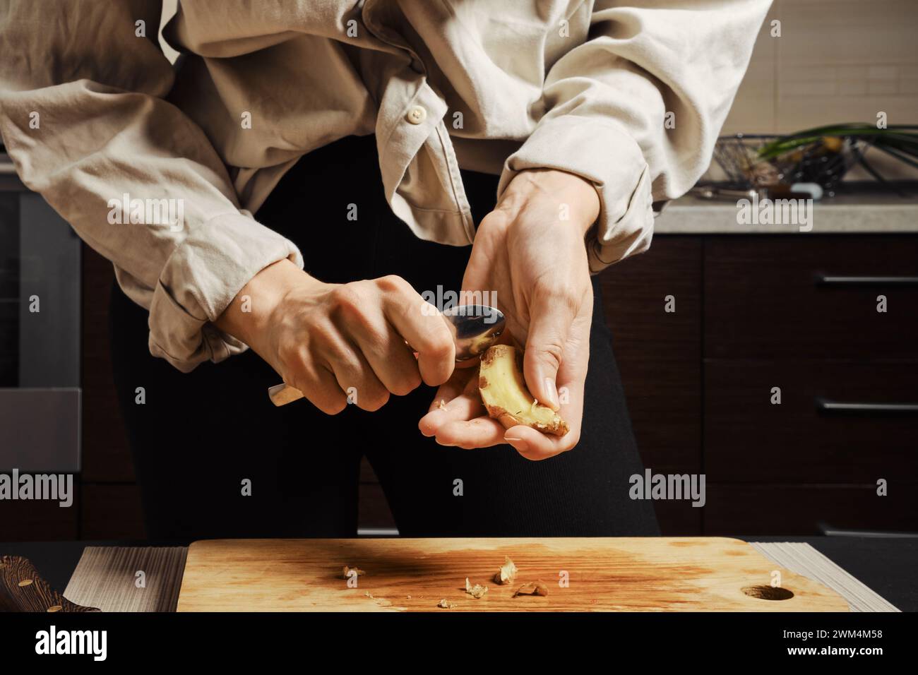 Female hands peeling ginger with spoon in the kitchen Stock Photo - Alamy