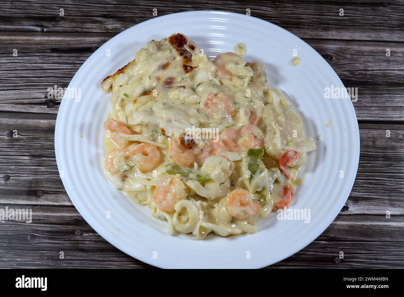 Creamy seafood baked mix of shrimps, squid calamari, fish fillet ...