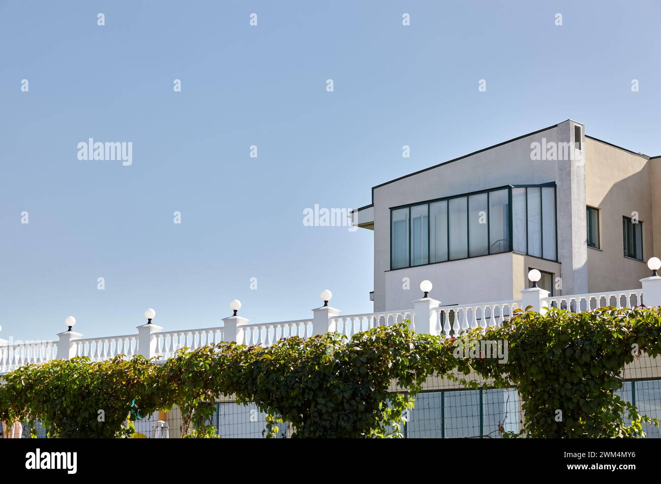 Fragment of the terrace with columns, lamps and railings. White stone ...