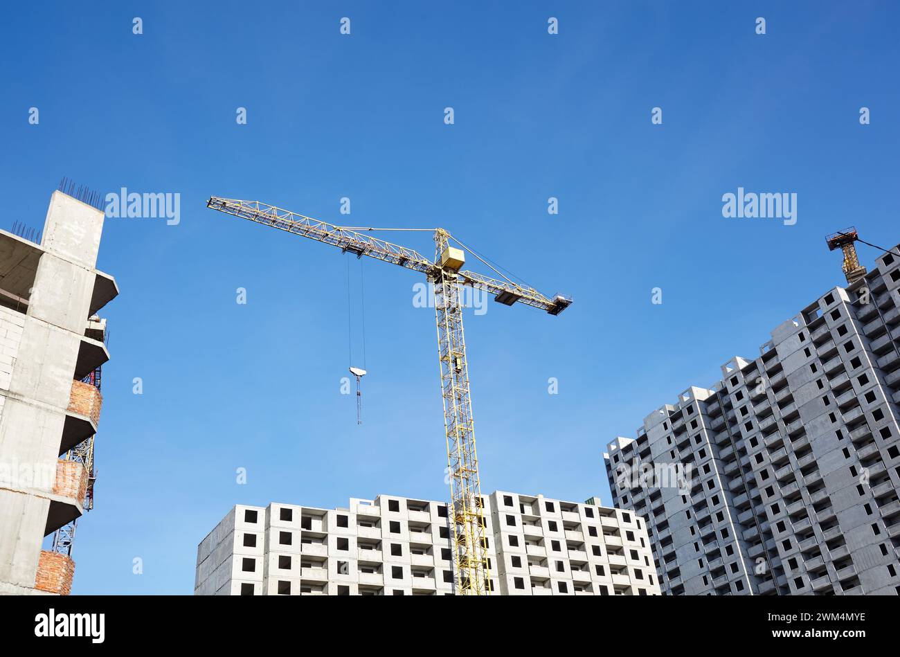 Tower crane building a house. Concrete building under construction ...