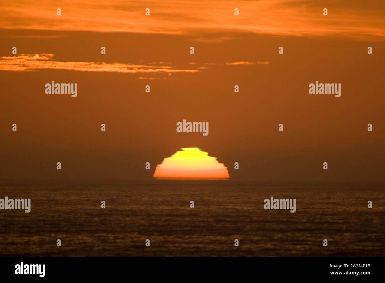 Sunsetting green flash with clouds from the eastern horizon as seen ...