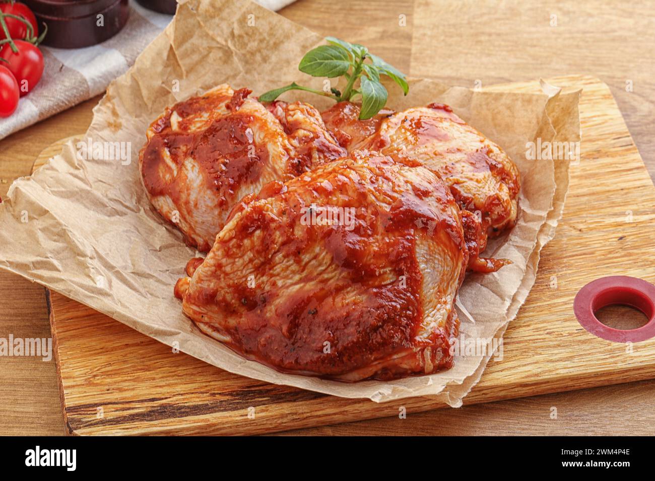 Marinated chicken leg thighs in tomato sauce Stock Photo - Alamy