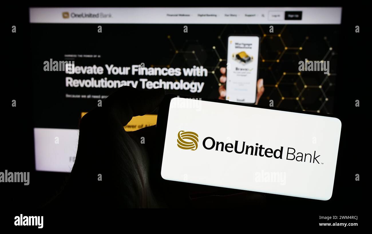 Person holding mobile phone with logo of American financial services ...
