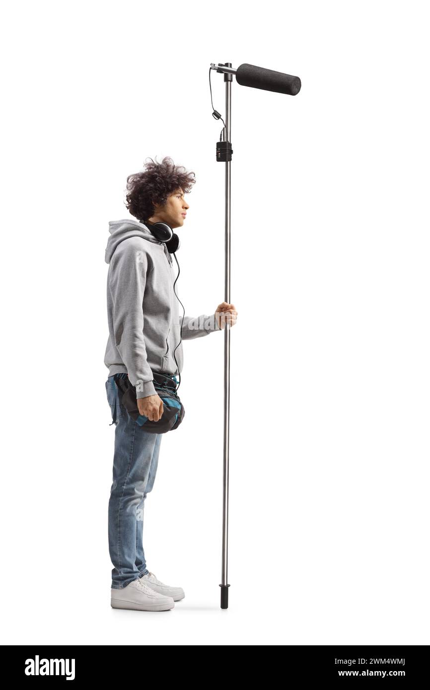Full length profile shot of a boom operator holding a microphone ...