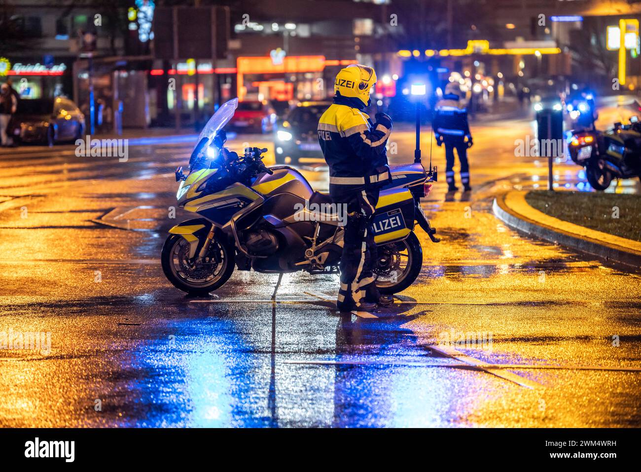 Policeman with motorbike, in rainy weather, blocking a road, police ...