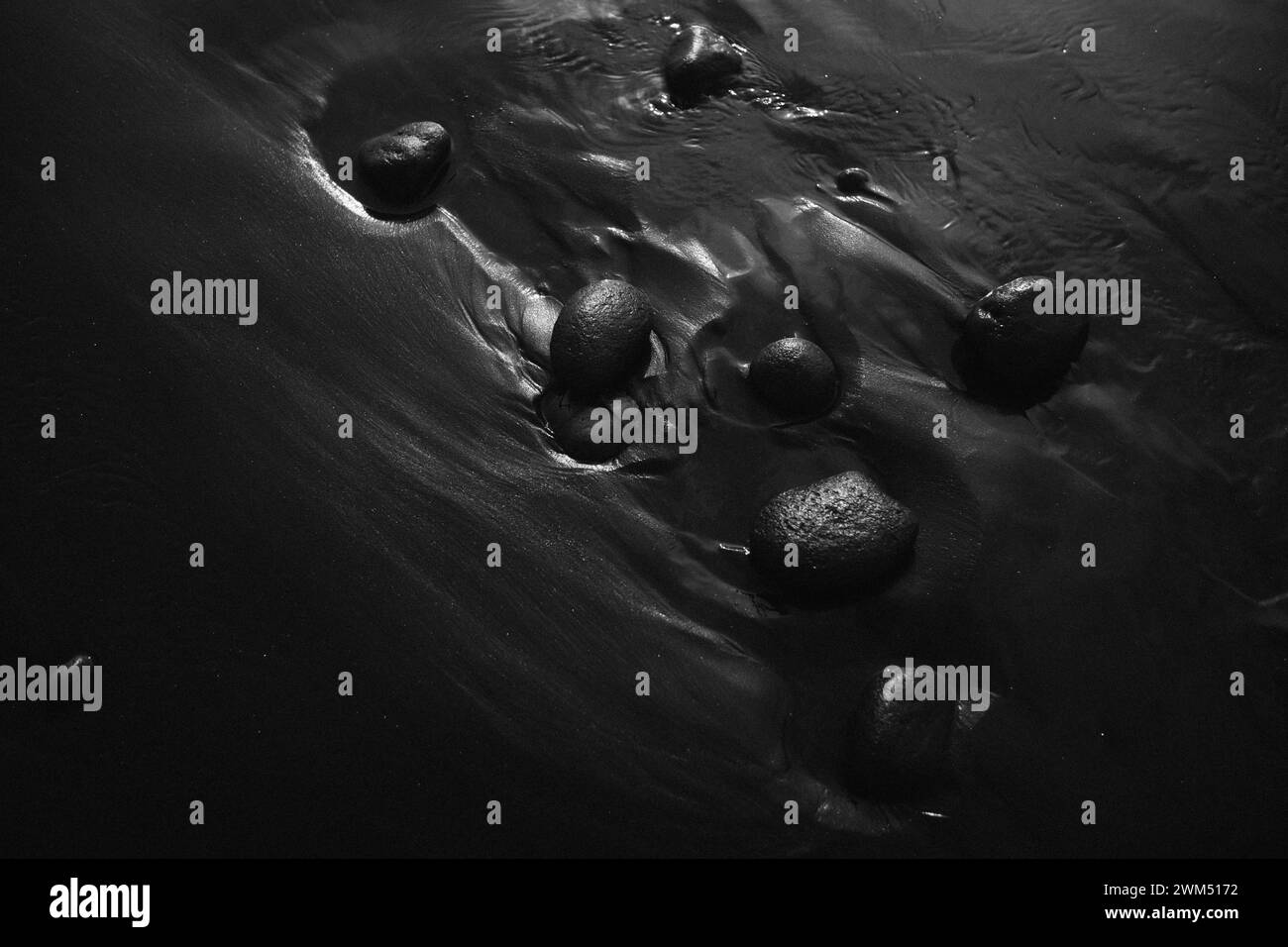 Bed of rocks on the beach during sunset Stock Photo - Alamy