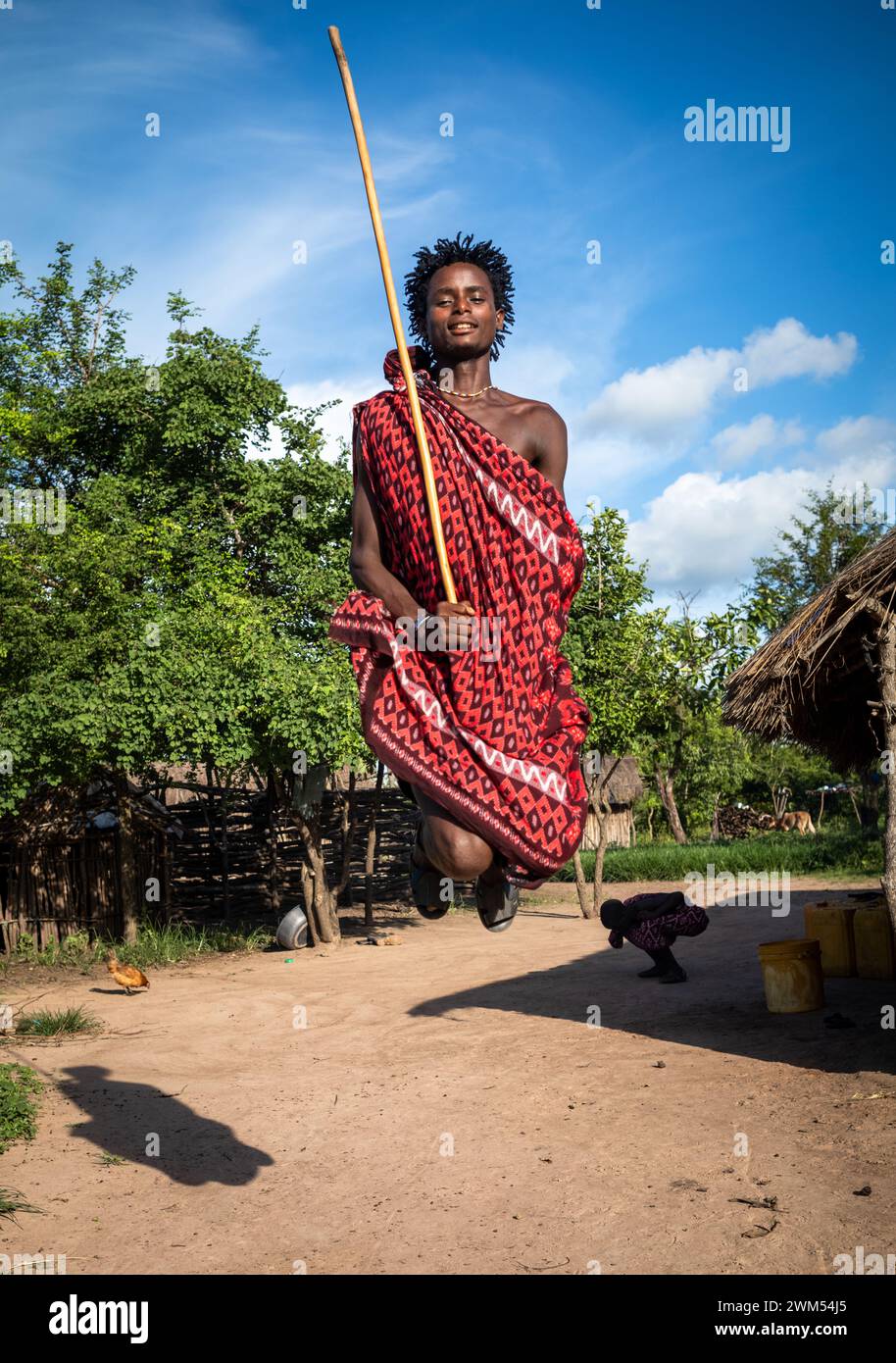 A young Maasai warrior performs the traditional jumping dance in his ...