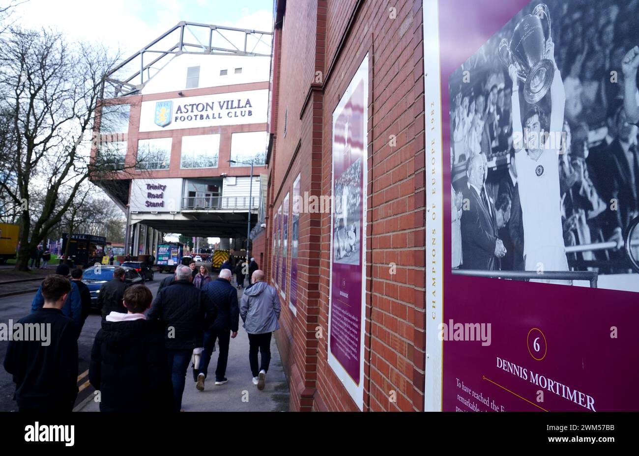 Fans walk a sign for former player Dennis Mortimer as they make their ...