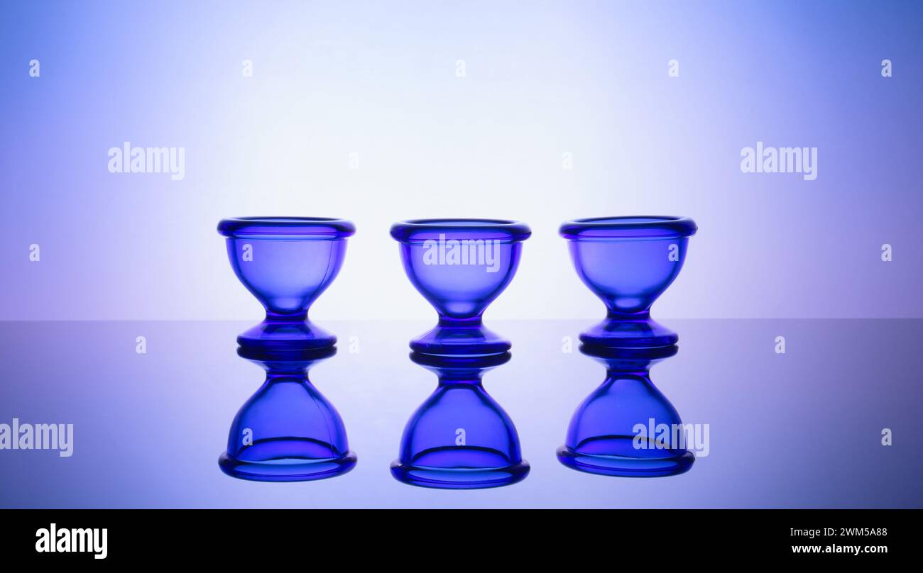 Beautiful assortment of blue glass tableware set on a softly glowing ...
